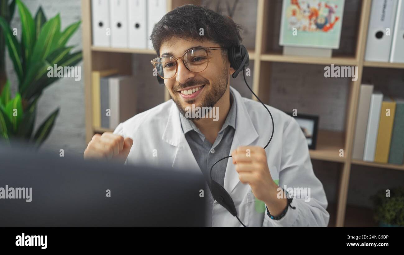 A cheerful man in a headset celebrates a successful moment at his ...