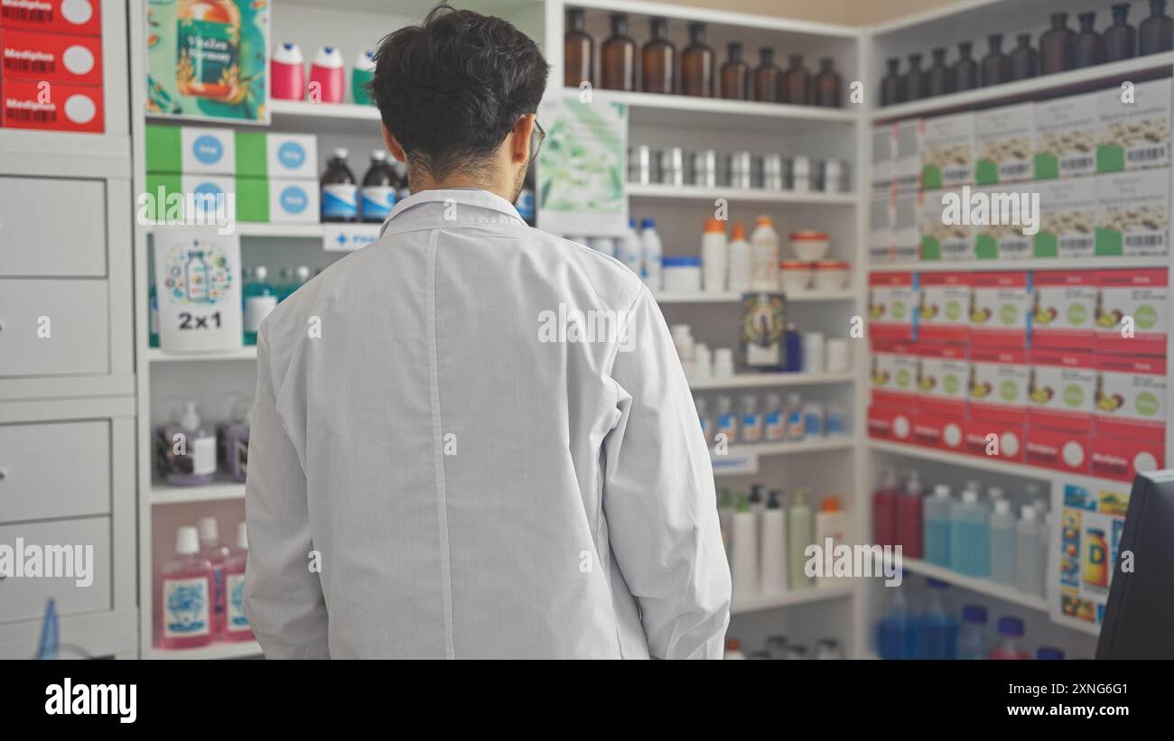 Back view of a man in a white coat browsing products in a pharmacy ...