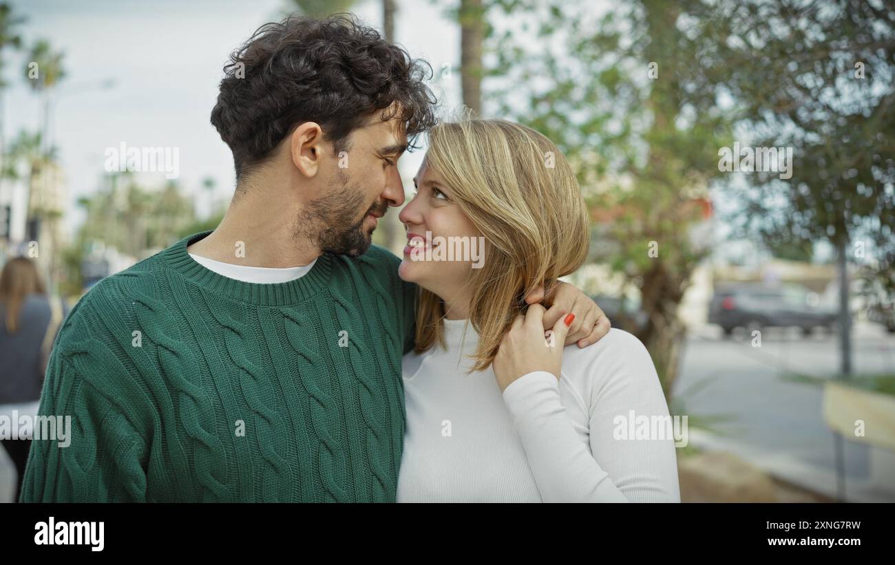 Intimate couple embracing lovingly on a city street, conveying a deep ...