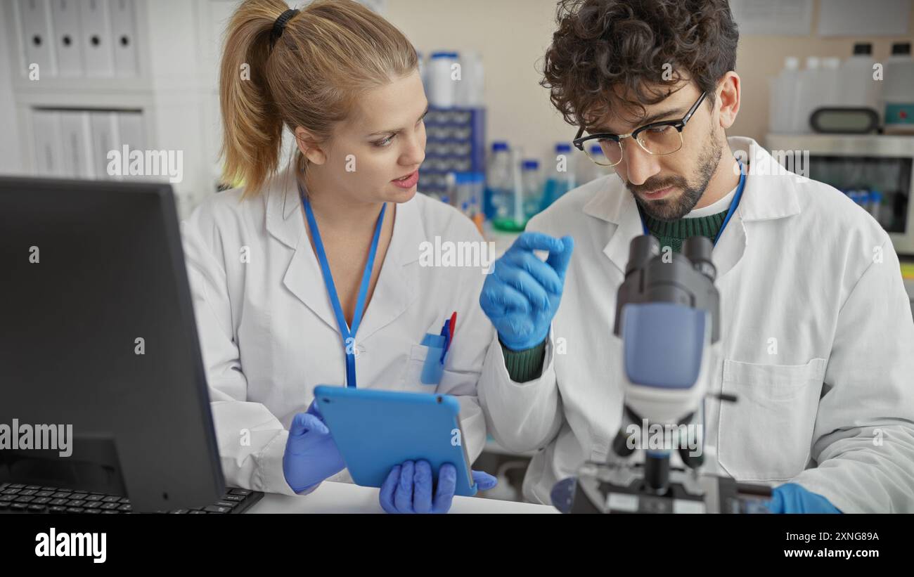A woman and man scientists collaborating in a laboratory, analyzing samples under a microscope ...