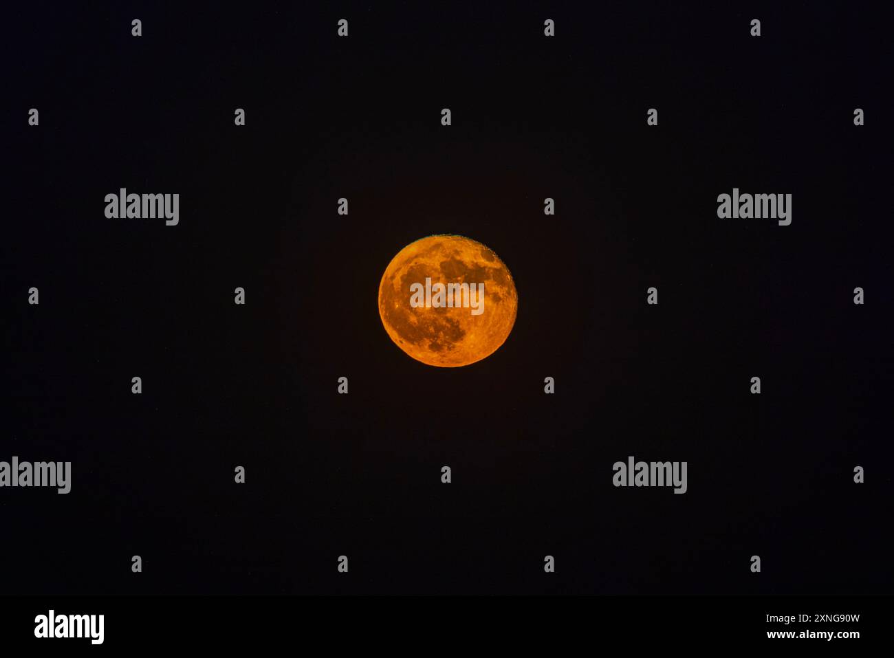 Full moon in the night sky, glowing in red-orange hues with visible ...