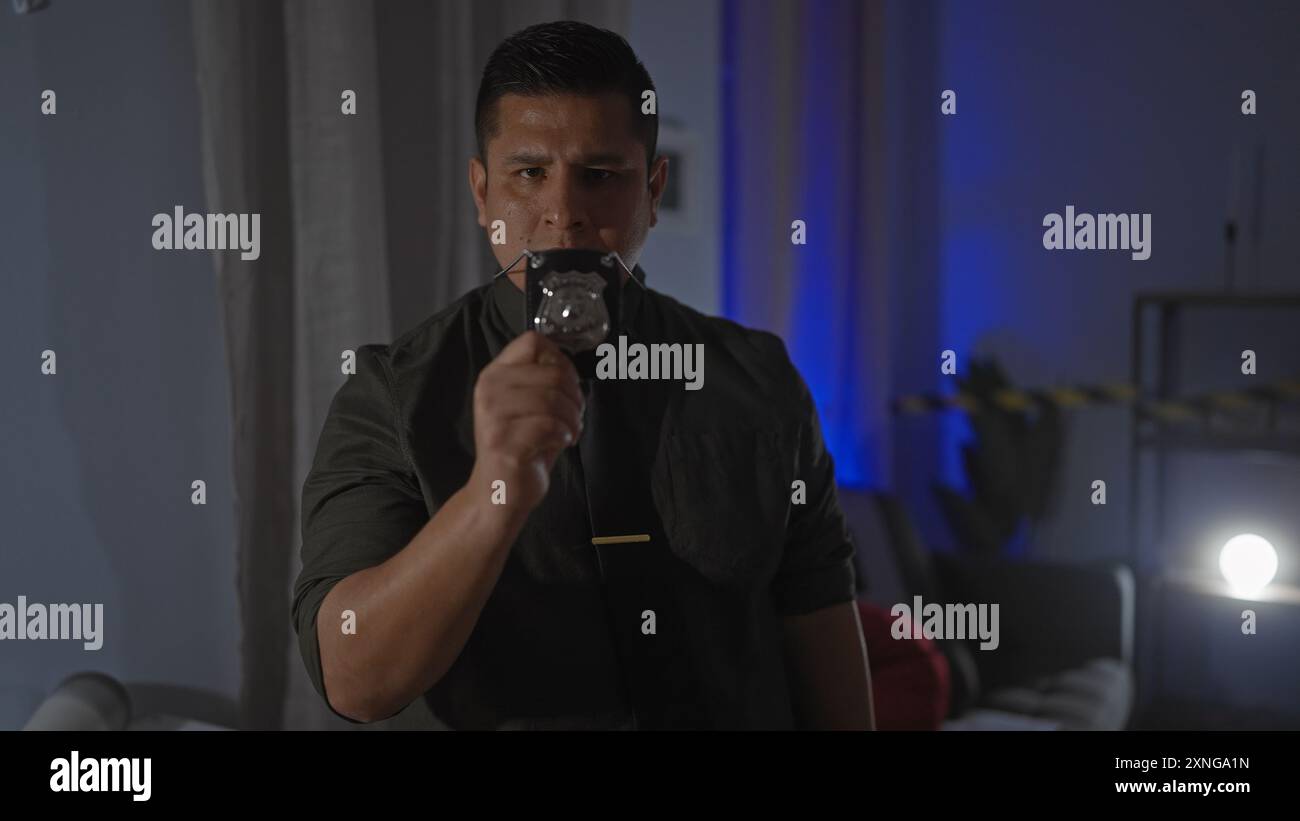 Hispanic detective man holding badge in illuminated dark living room ...