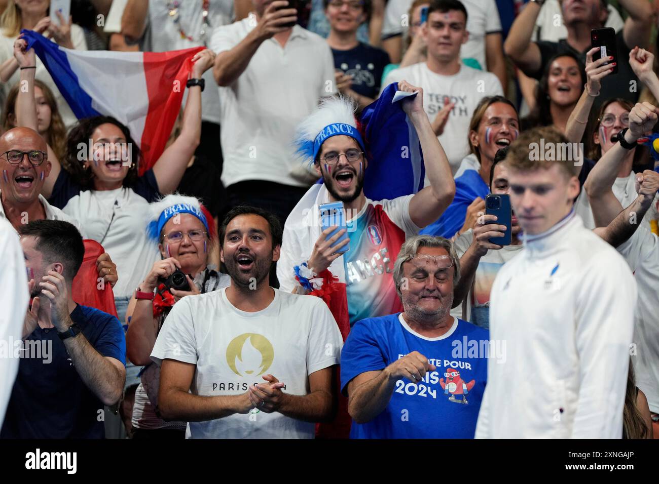 Supporters of Leon Marchand, of France, cheer as he stands on the ...