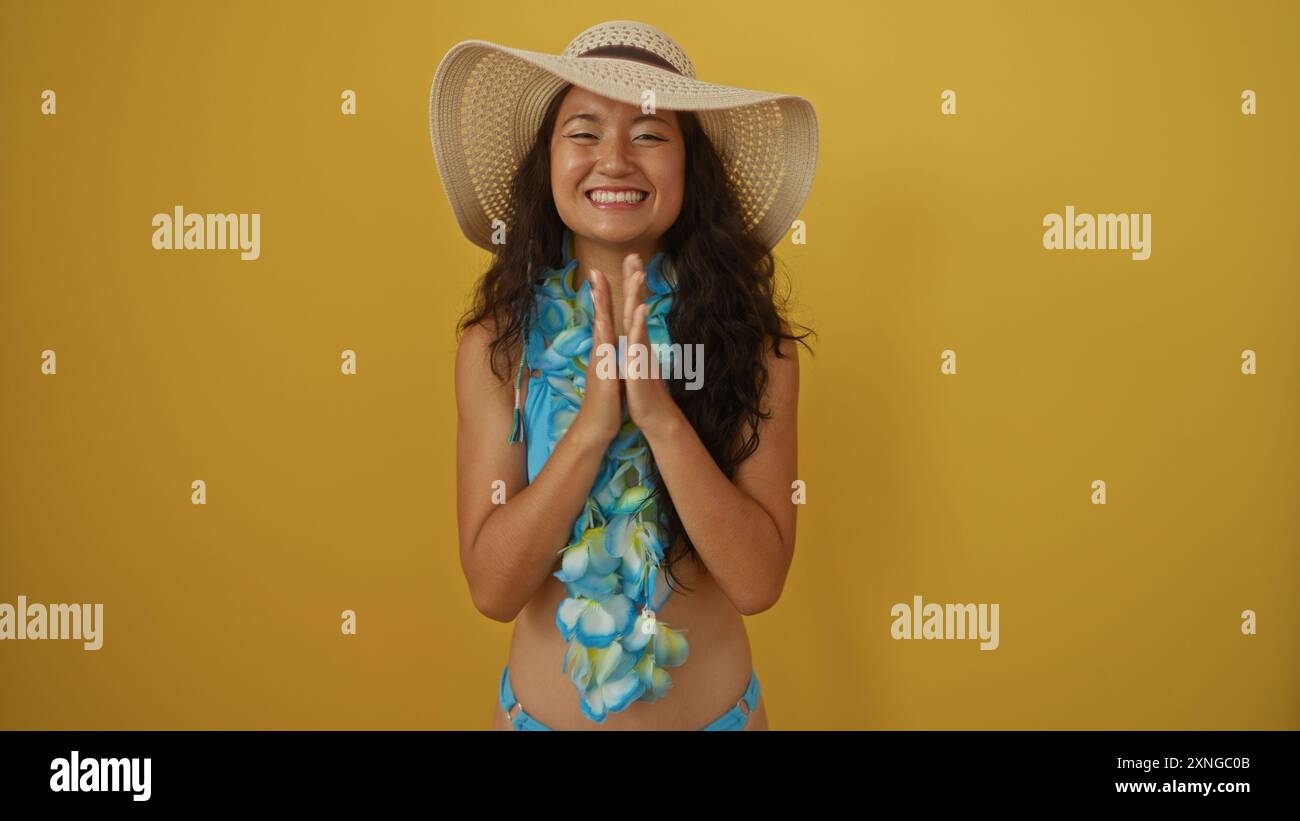Beautiful young chinese woman in a blue bikini and floral lei smiling ...