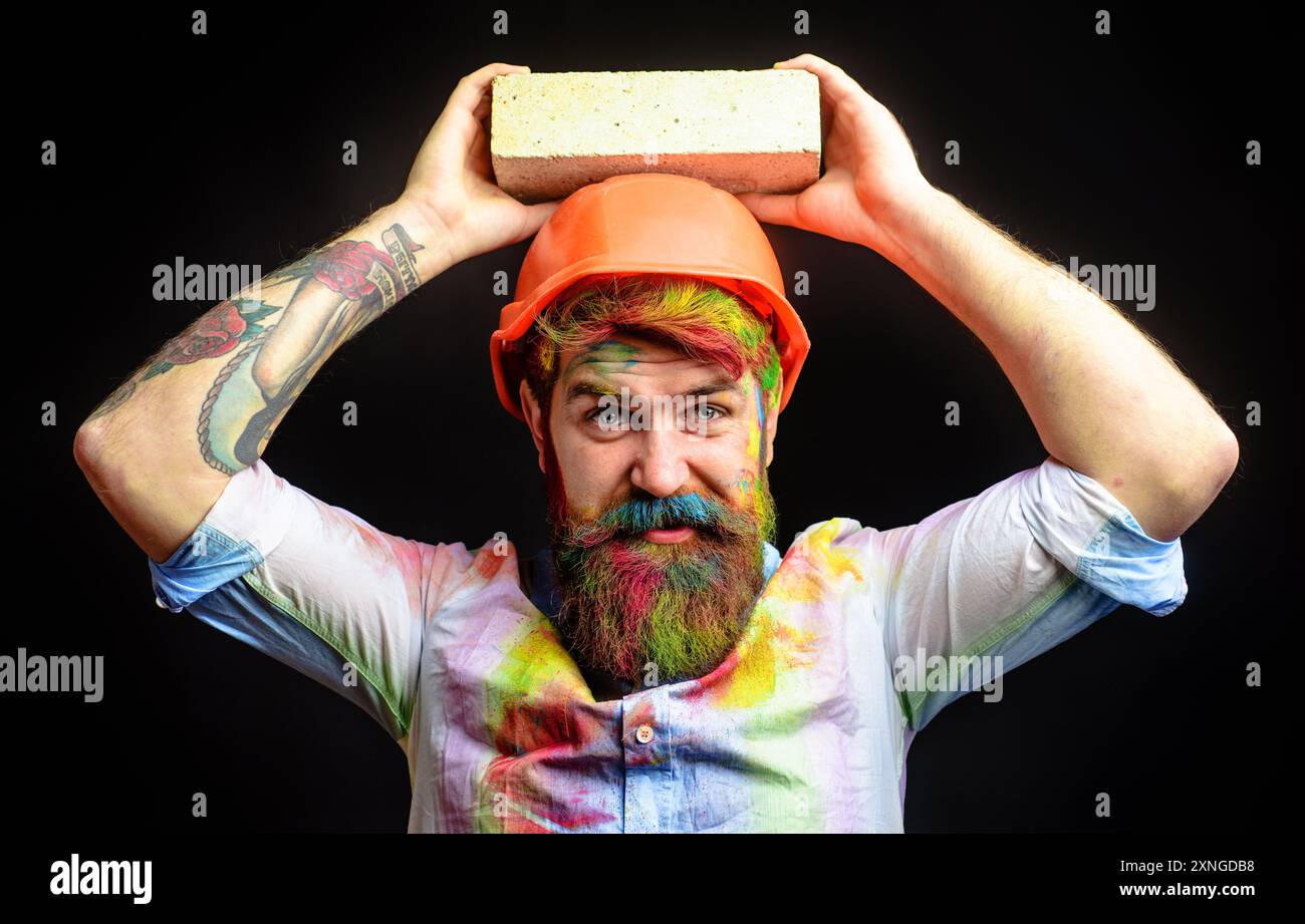 Bearded construction worker in safety helmet with brick. Portrait of ...
