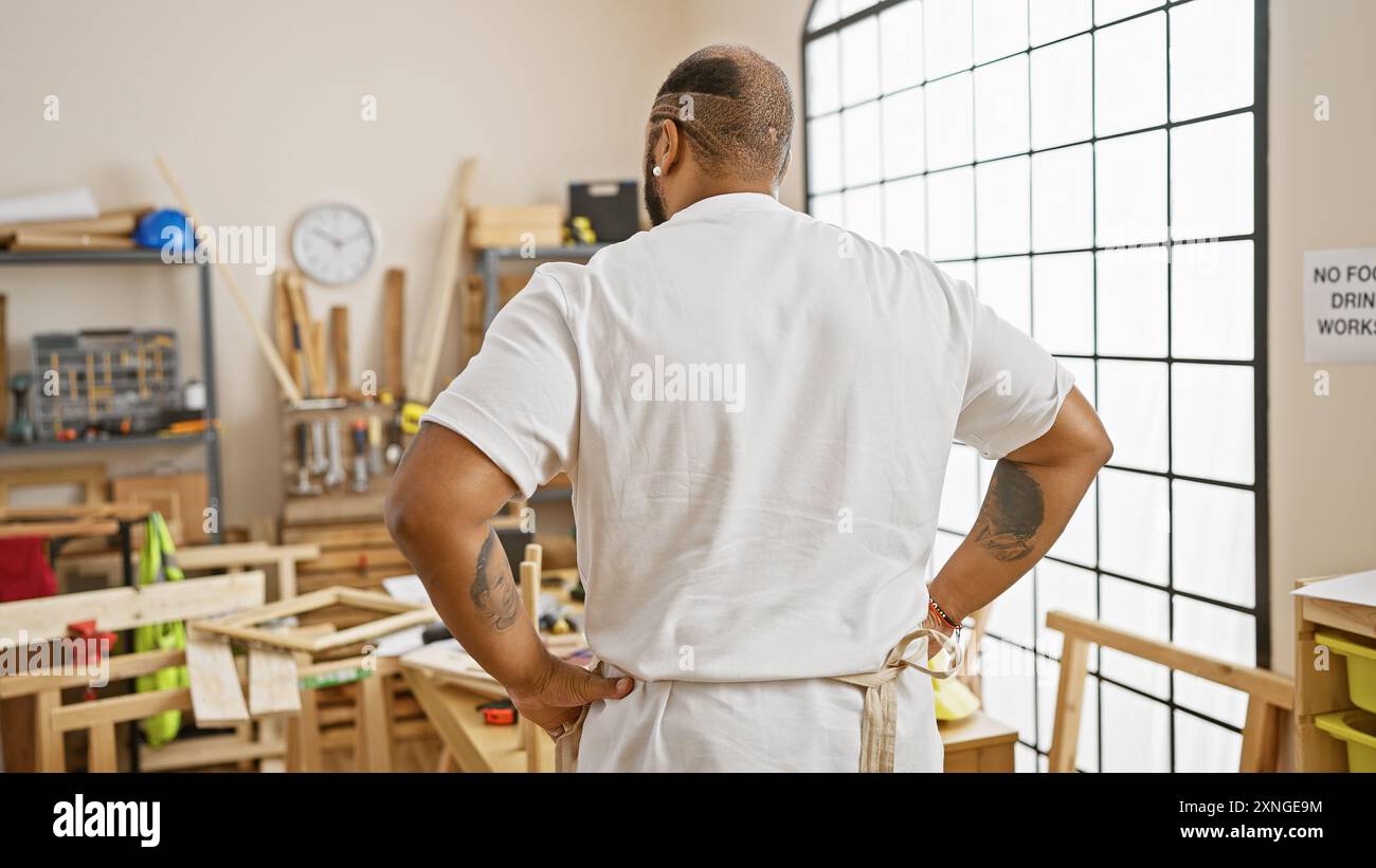 African american craftsman contemplates his project in a well-equipped ...