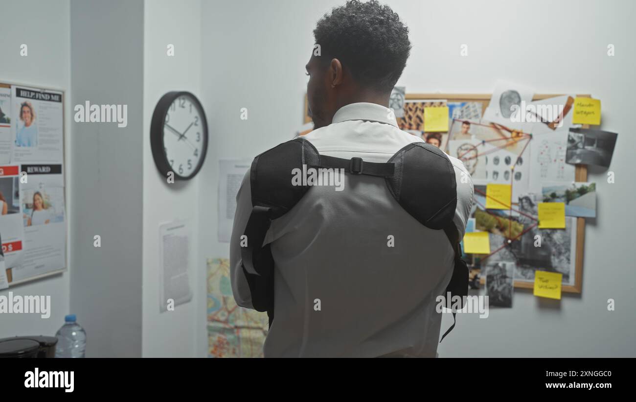 Back view of an african american male detective analyzing a crime ...