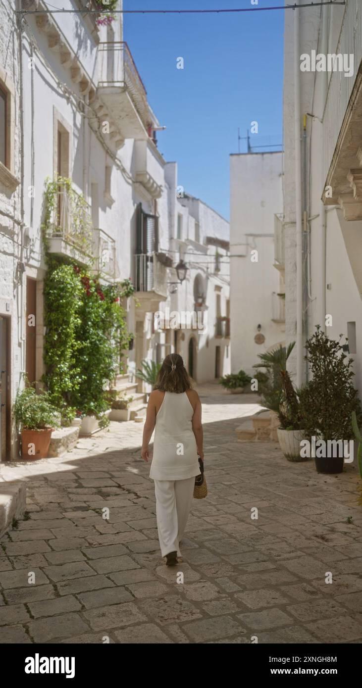 A young hispanic woman strolls through the charming old town streets of ...