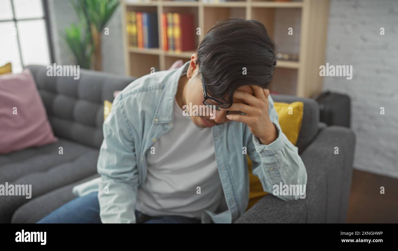 Asian man feeling stressed sitting in a modern living room Stock Photo ...