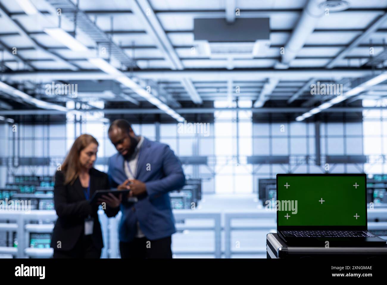 Software developers using green screen laptop in data center, making sure rigs are functioning ...
