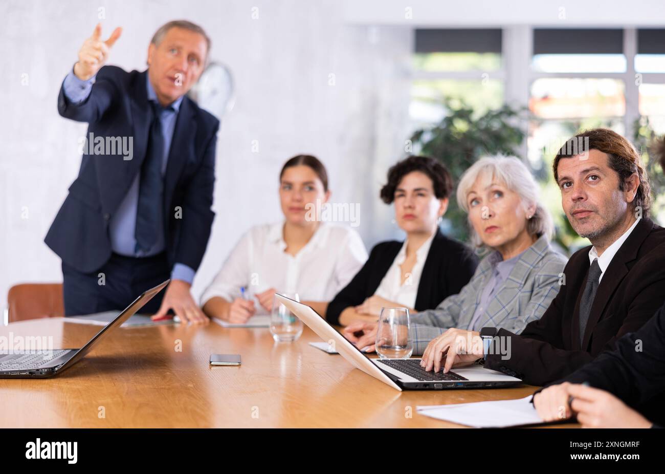 Focused businessman listening to presentation of partners during ...