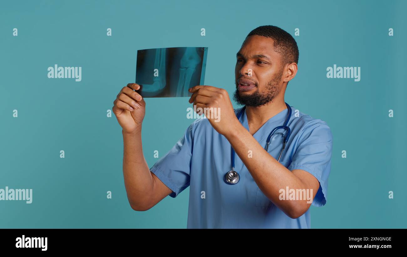 Male nurse analyzing radiology x ray scan to provide patient with ...