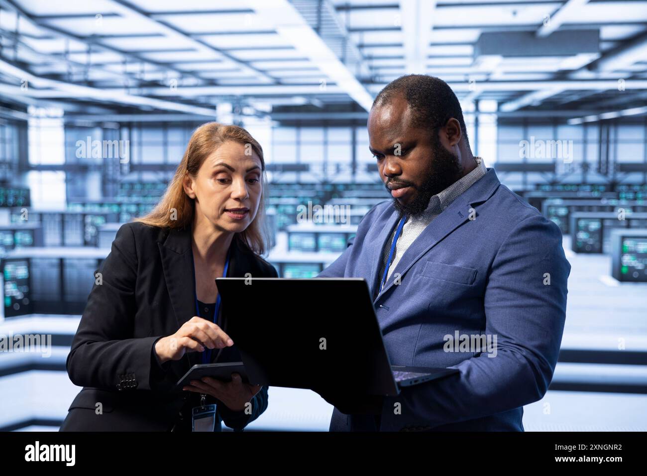 Team of programmers in server room using laptop to implement and maintain security measures ...