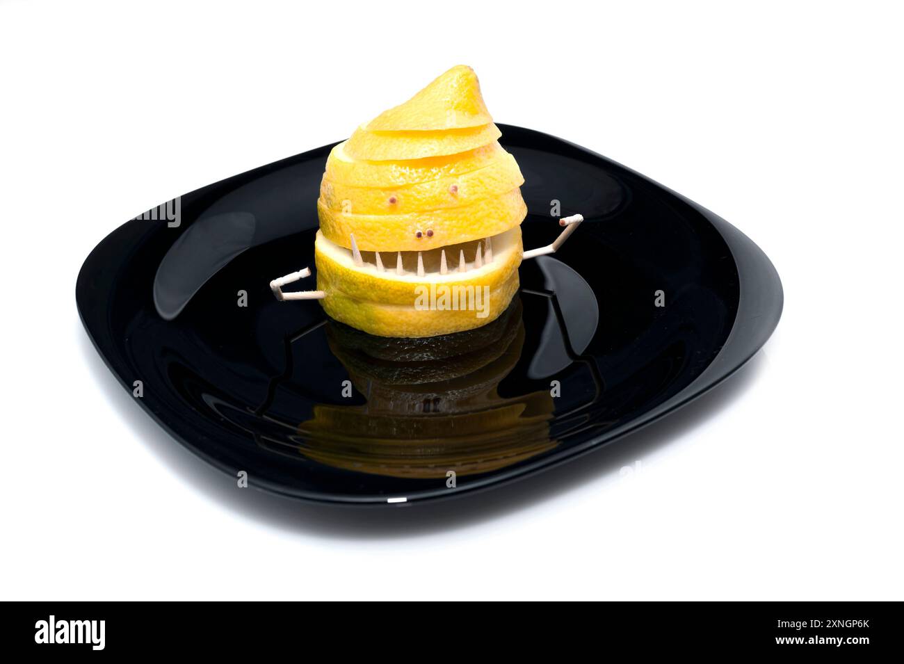 lemon on black plate appearing teeth and mouth Stock Photo - Alamy