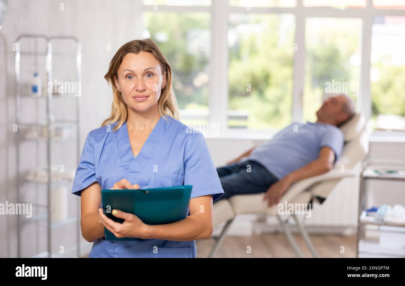 Adult woman doctor making notes in medical office Stock Photo - Alamy