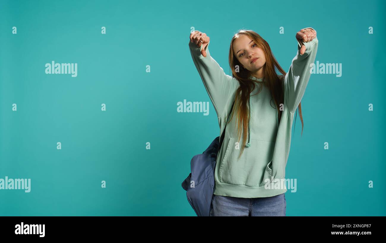 Frustrated woman showing thumbs down sign gesturing, disapproving and ...