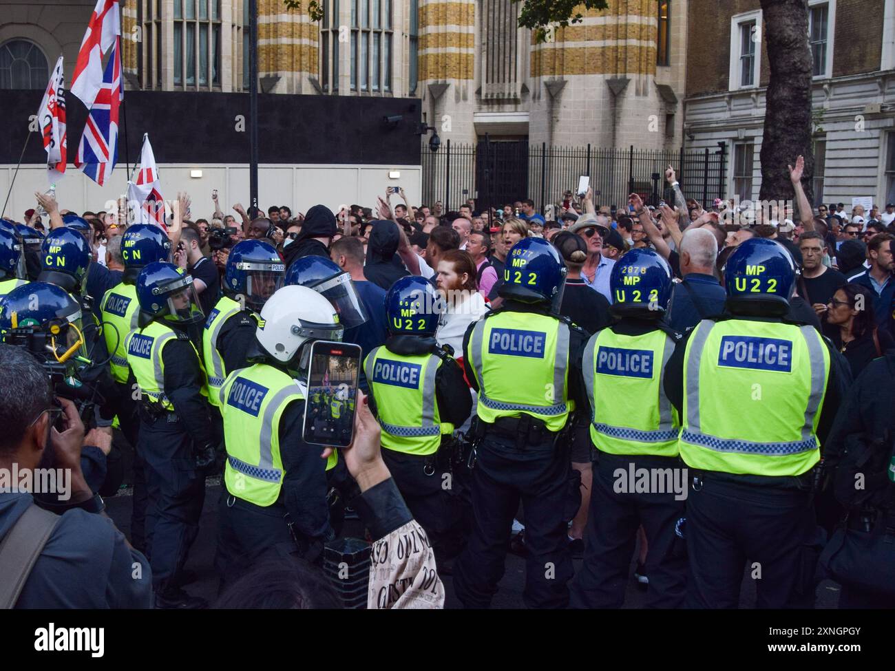 London, UK. 31st July 2024. Police in riot gear face off with ...
