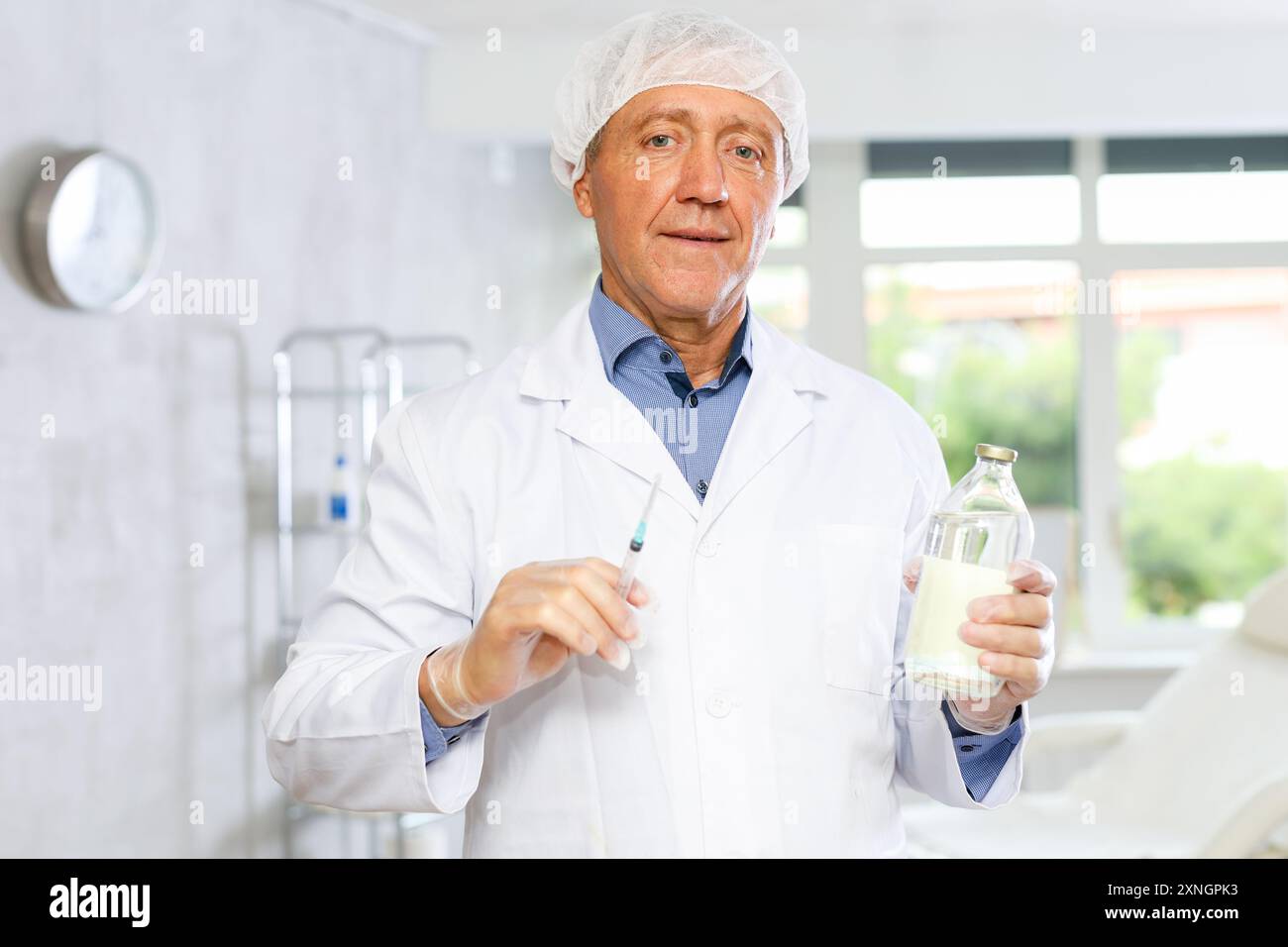 Old man doctor posing in doctor's cabinet with injector in hand Stock ...