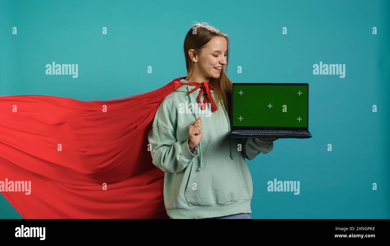 Young girl wearing superhero costume presenting and talking about green ...