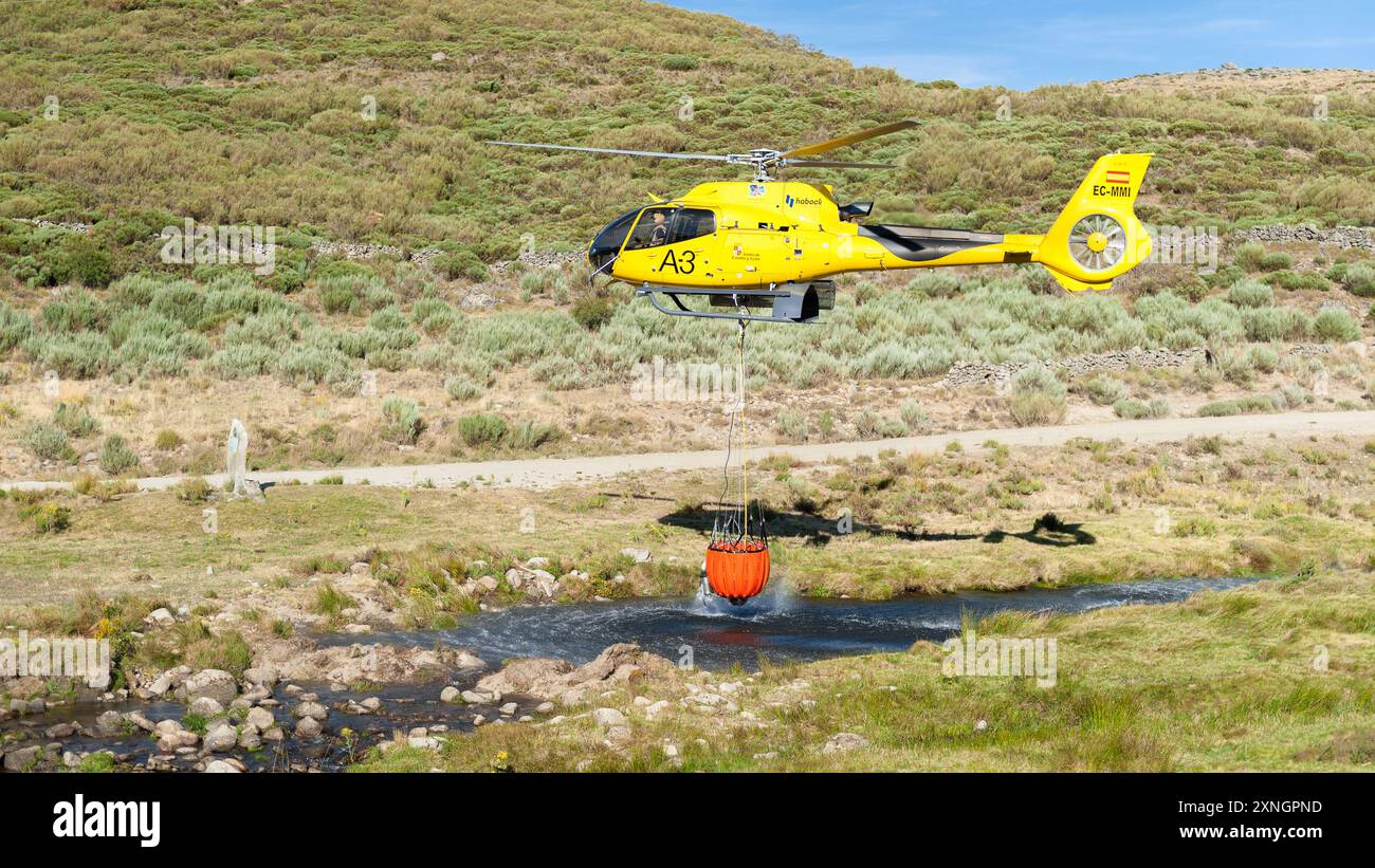 Helicopter on river bed with basket full of water Stock Photo - Alamy
