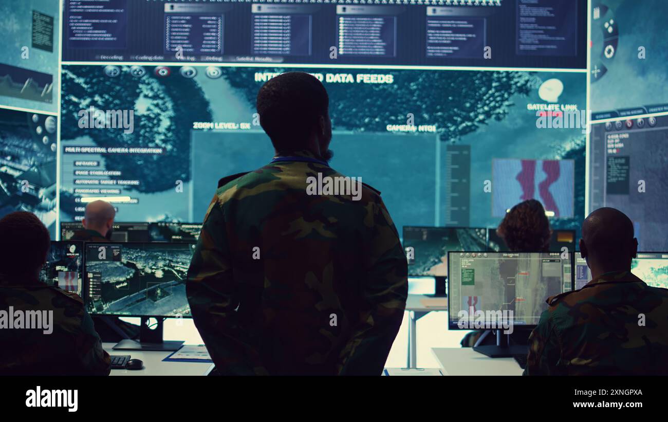 Staff sergeant monitoring satellite live imagery on a big screen ...