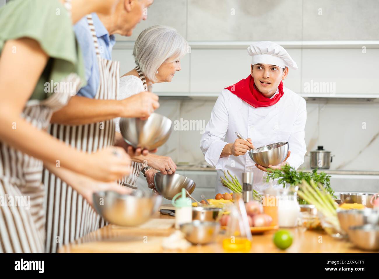 Young guy cook teaches to cook group of people Stock Photo - Alamy