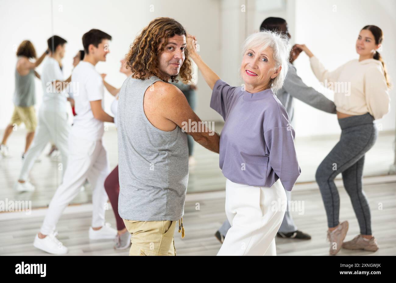 Dancing positive couples learning salsa Stock Photo - Alamy