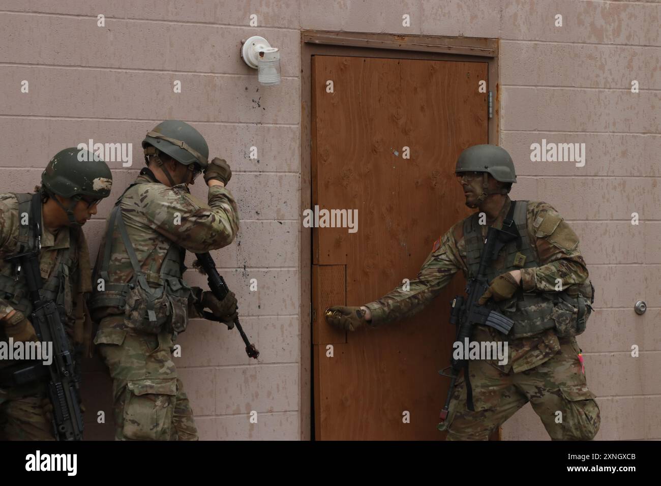 U.S. Army officer candidates stack up to clear up a room during phase ...