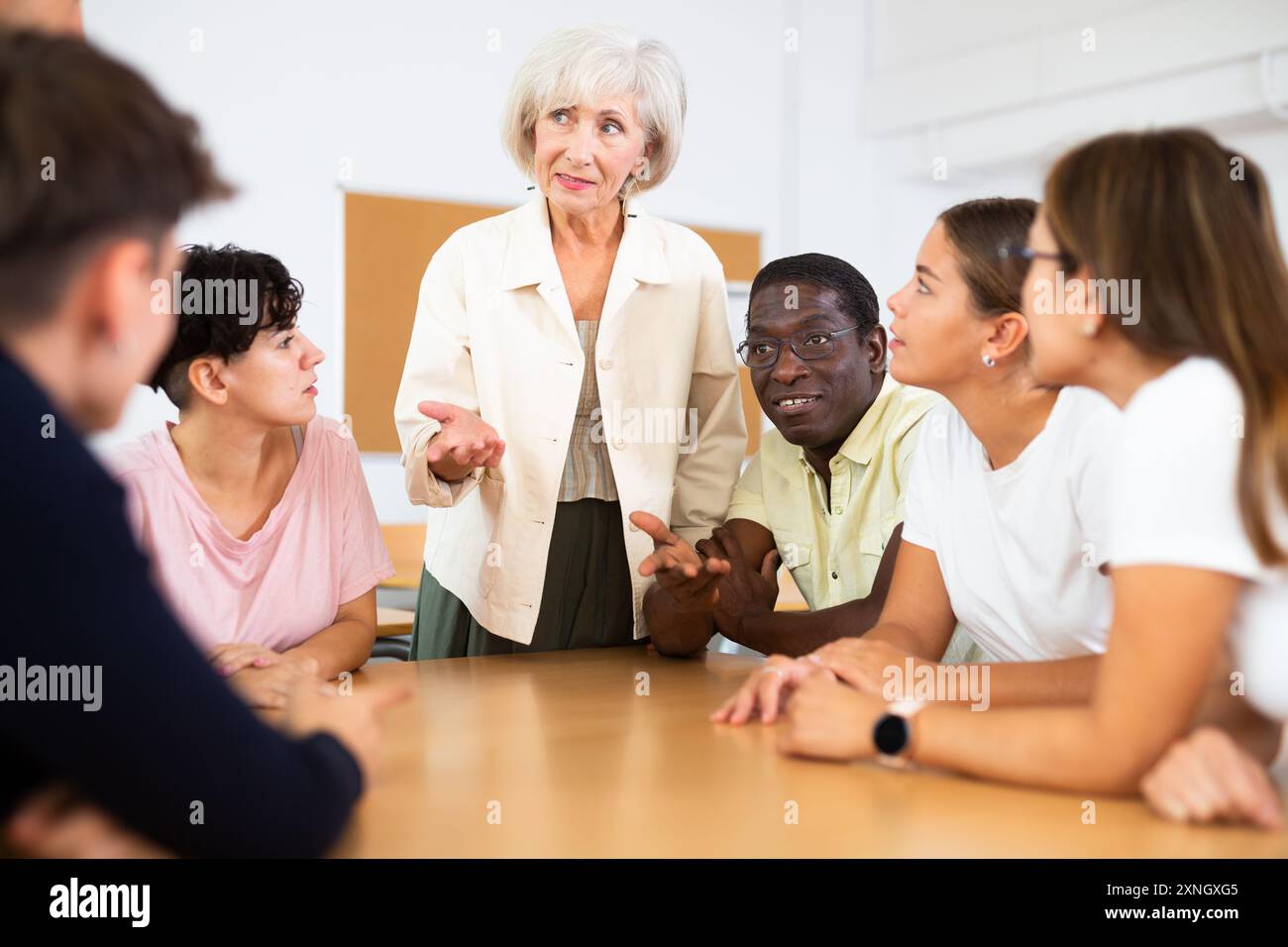 Elderly teacher, together with students of different ages, conducts ...