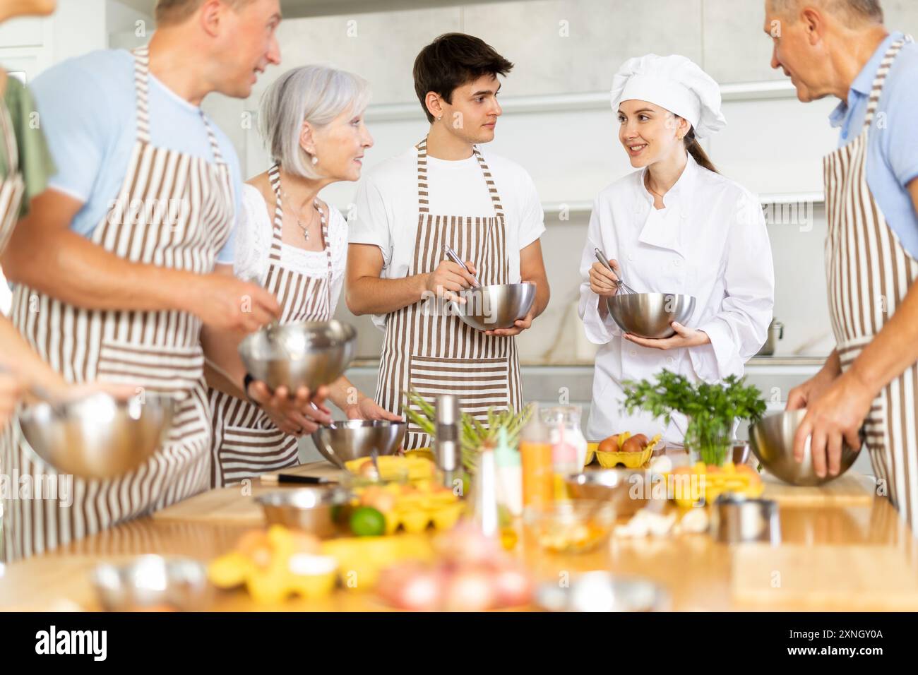 Young female chef running culinary courses for group of people Stock ...