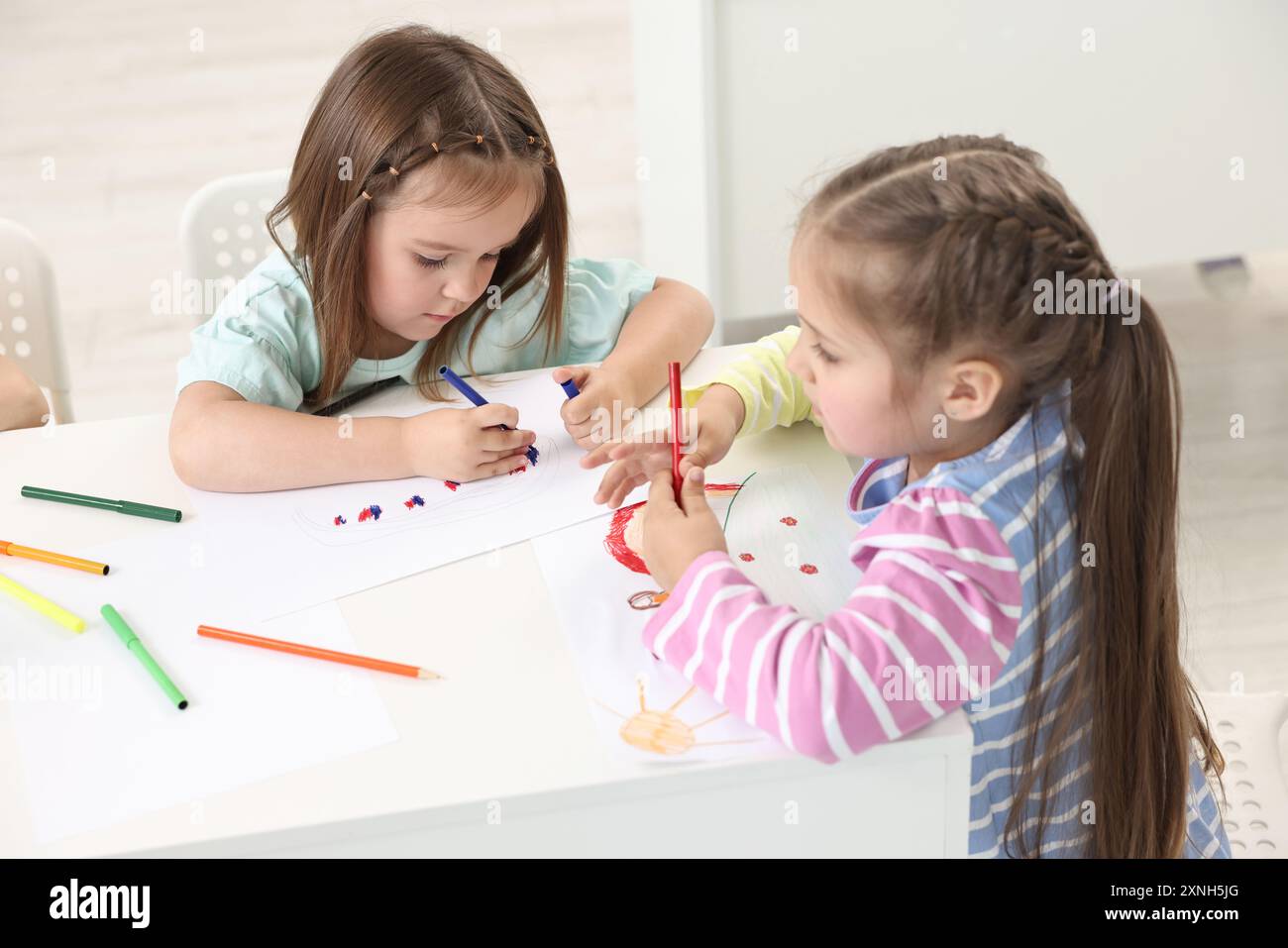 Cute little children drawing at table indoors Stock Photo - Alamy