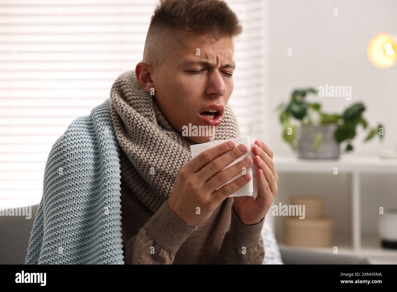 Cold symptom. Young man coughing at home Stock Photo - Alamy