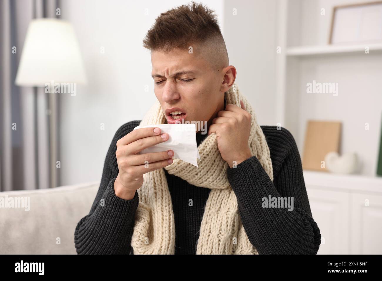 Cold symptom. Young man with runny nose at home Stock Photo - Alamy