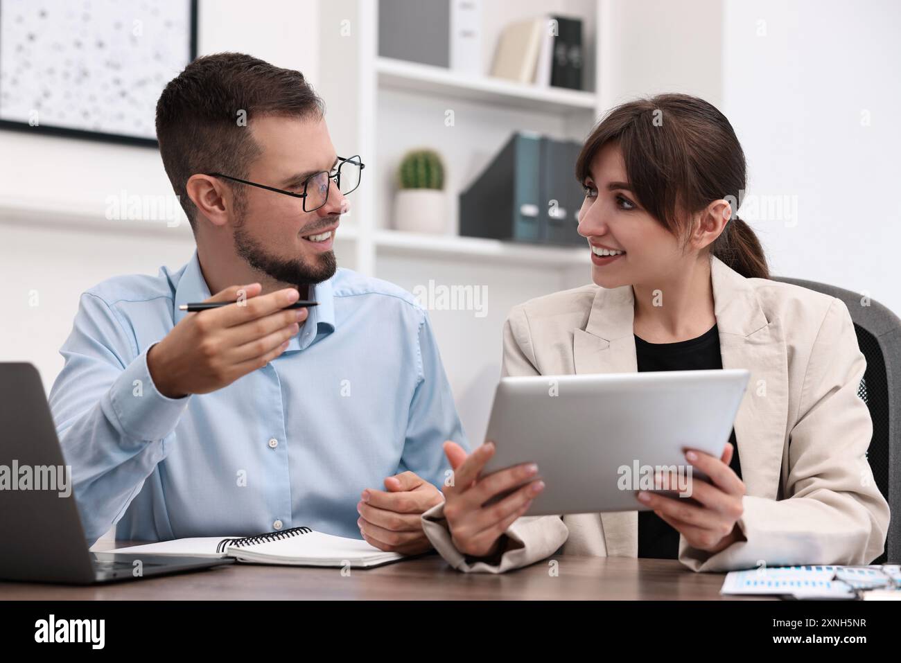 Consultant working with client at table in office. Business meeting ...