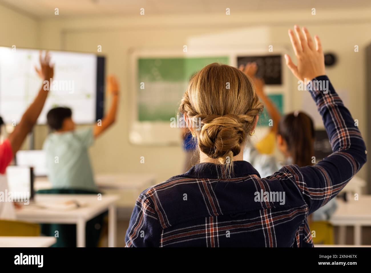 In high school, students raising hands in classroom, actively ...