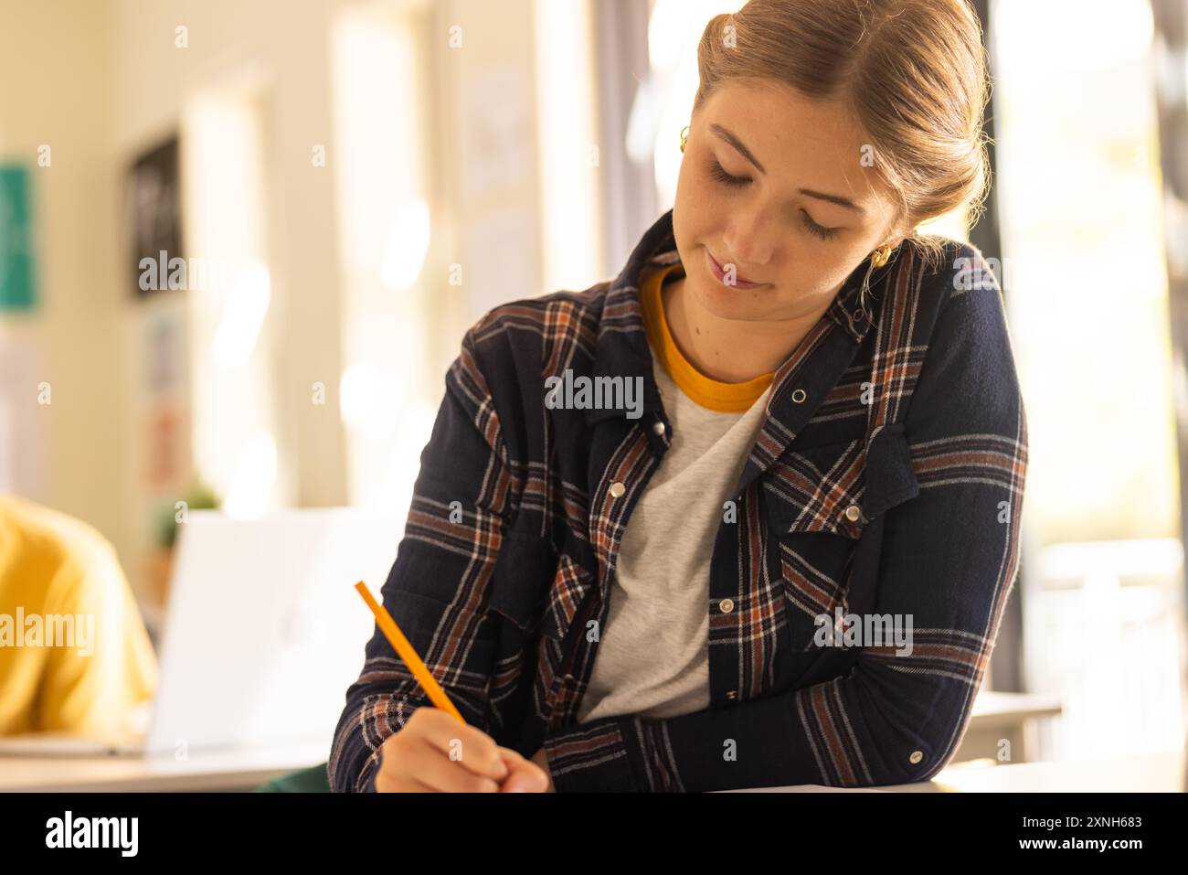 Teenage girl writing in notebook, studying attentively in high school ...
