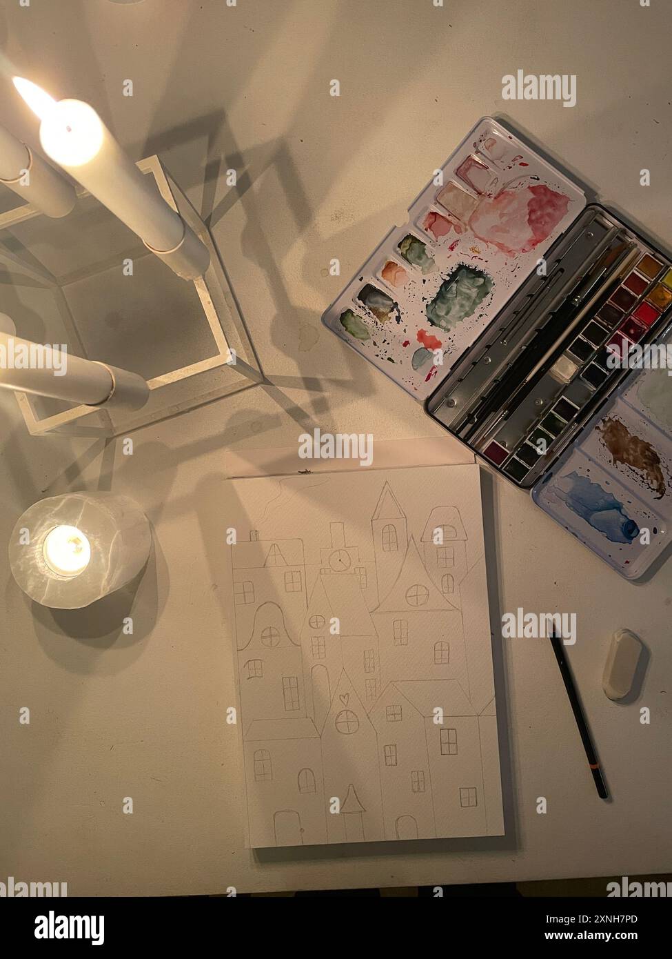 Creative workspace with a painting in progress, watercolors, and ...