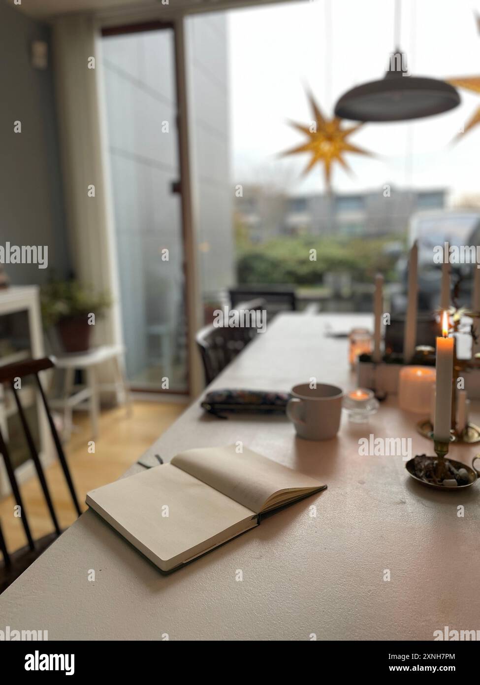 Cozy workspace with an open book, coffee, and a star decoration in the ...