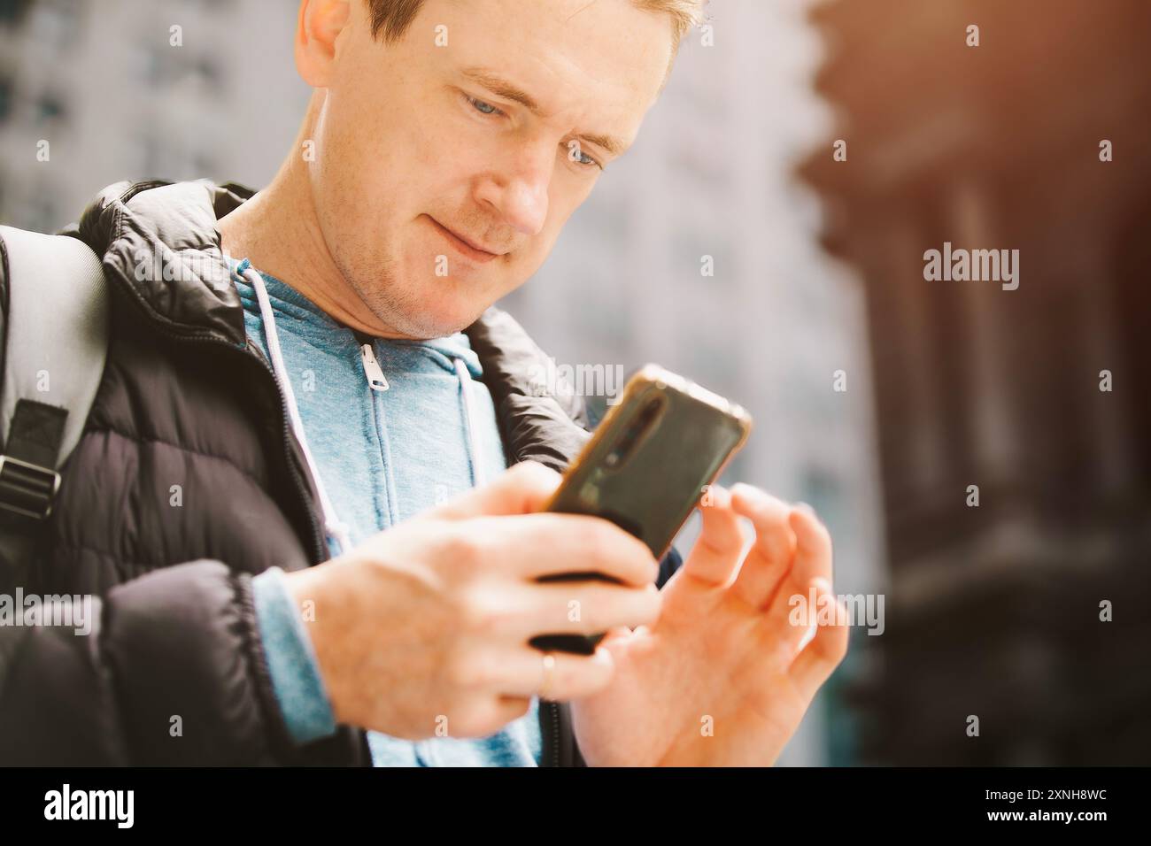 A man is using his cell phone on the street Stock Photo - Alamy