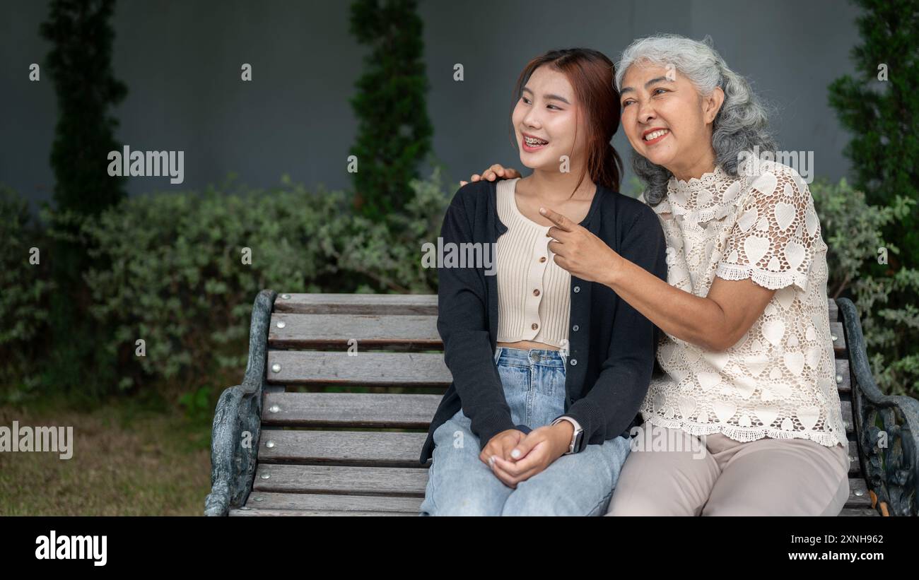 A happy retired Asian grandma is enjoying talking with her ...