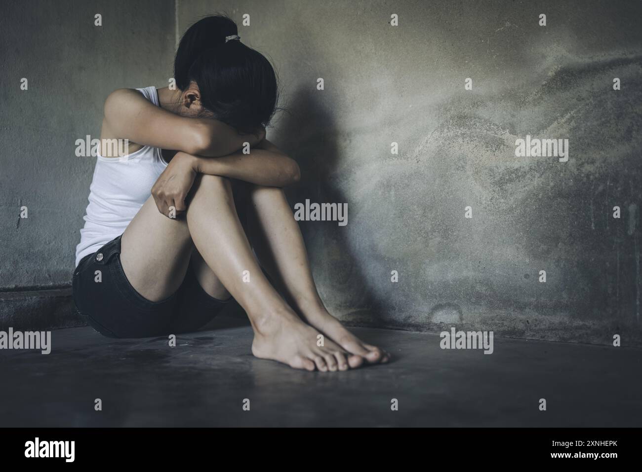 Young woman suffering from depression and anxiety sitting on the floor ...