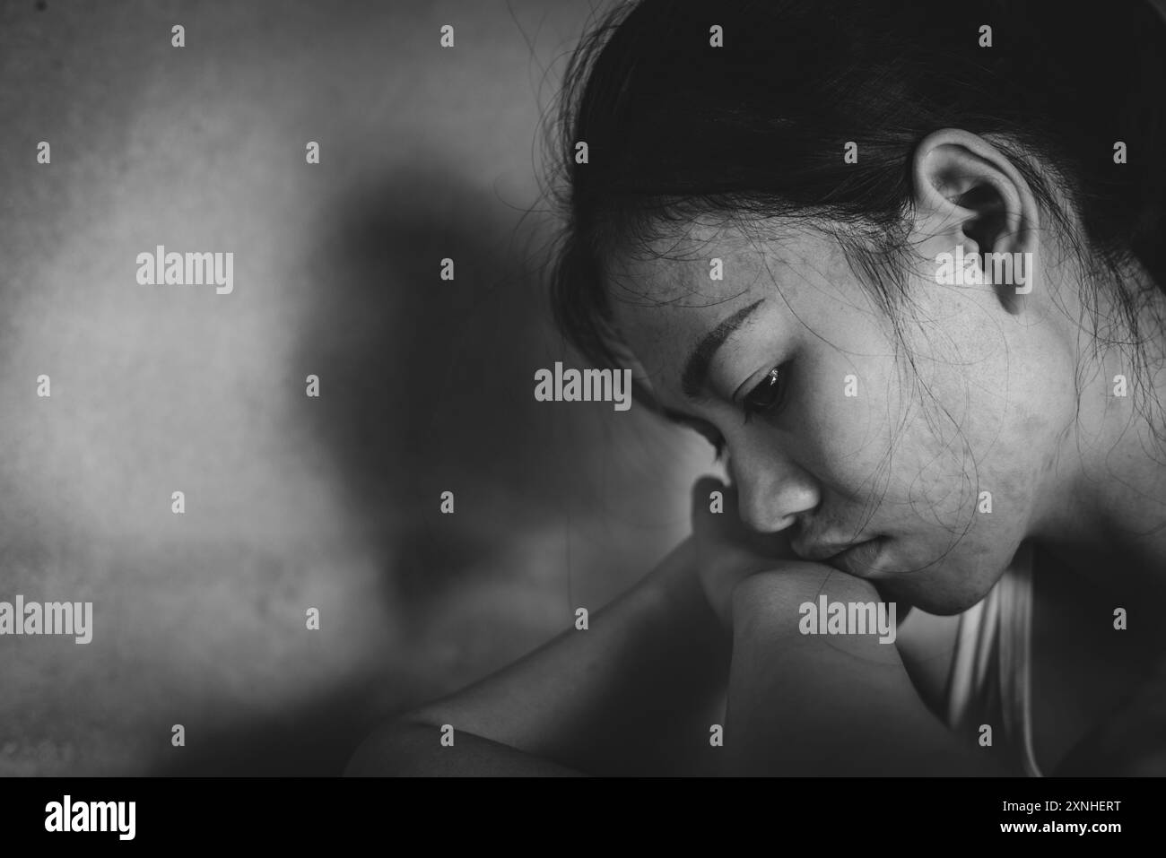 Young woman suffering from depression and anxiety sitting on the floor ...