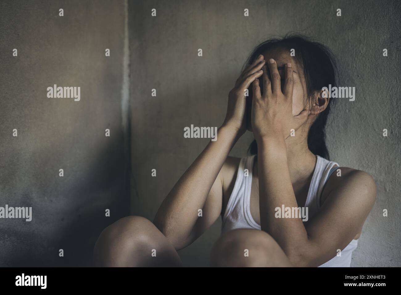 Young woman suffering from depression and anxiety sitting on the floor ...