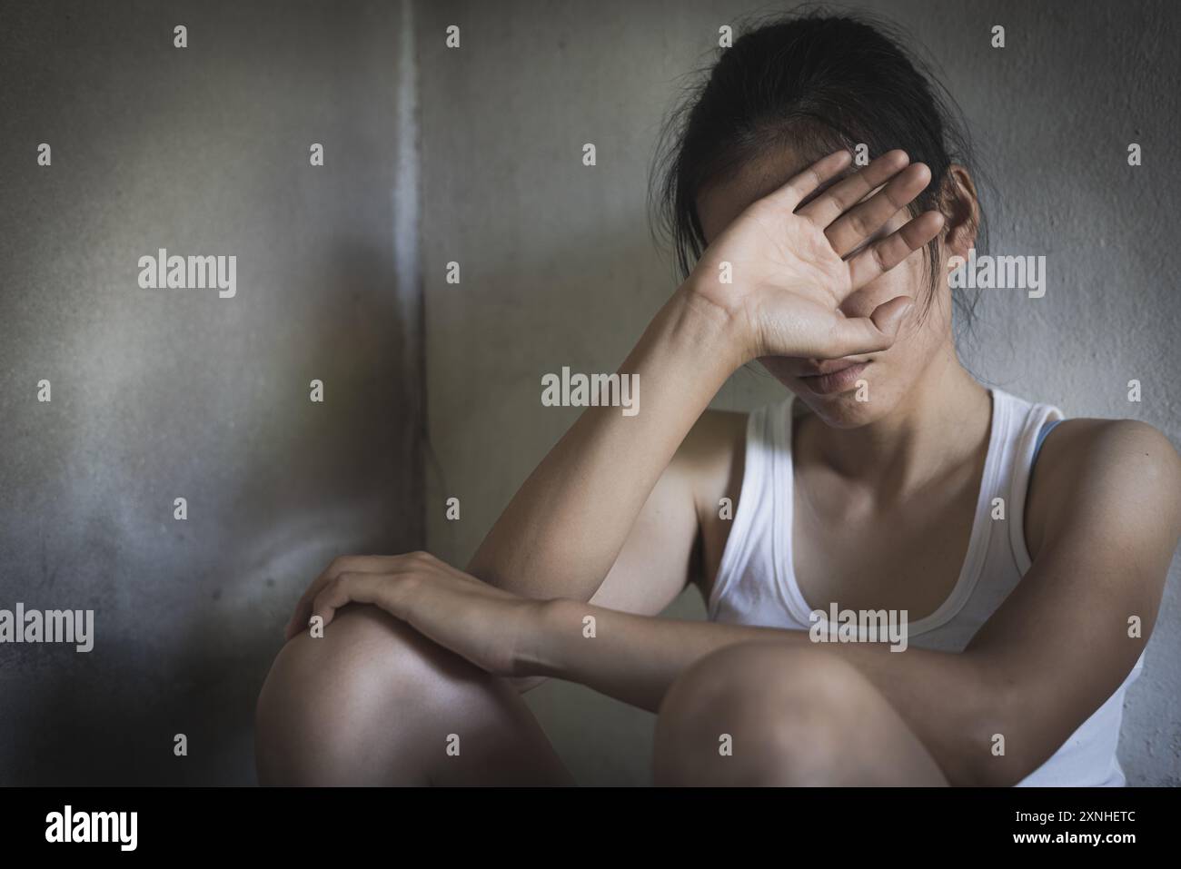 Young woman suffering from depression and anxiety sitting on the floor ...