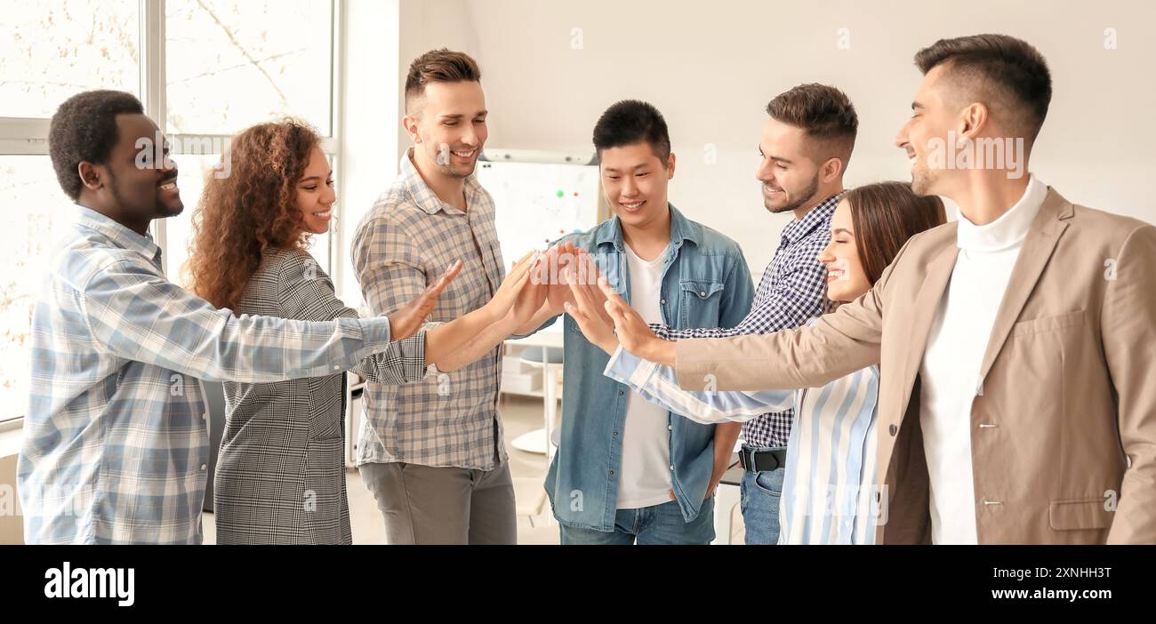 Group of people putting hands together indoors. Unity concept Stock ...