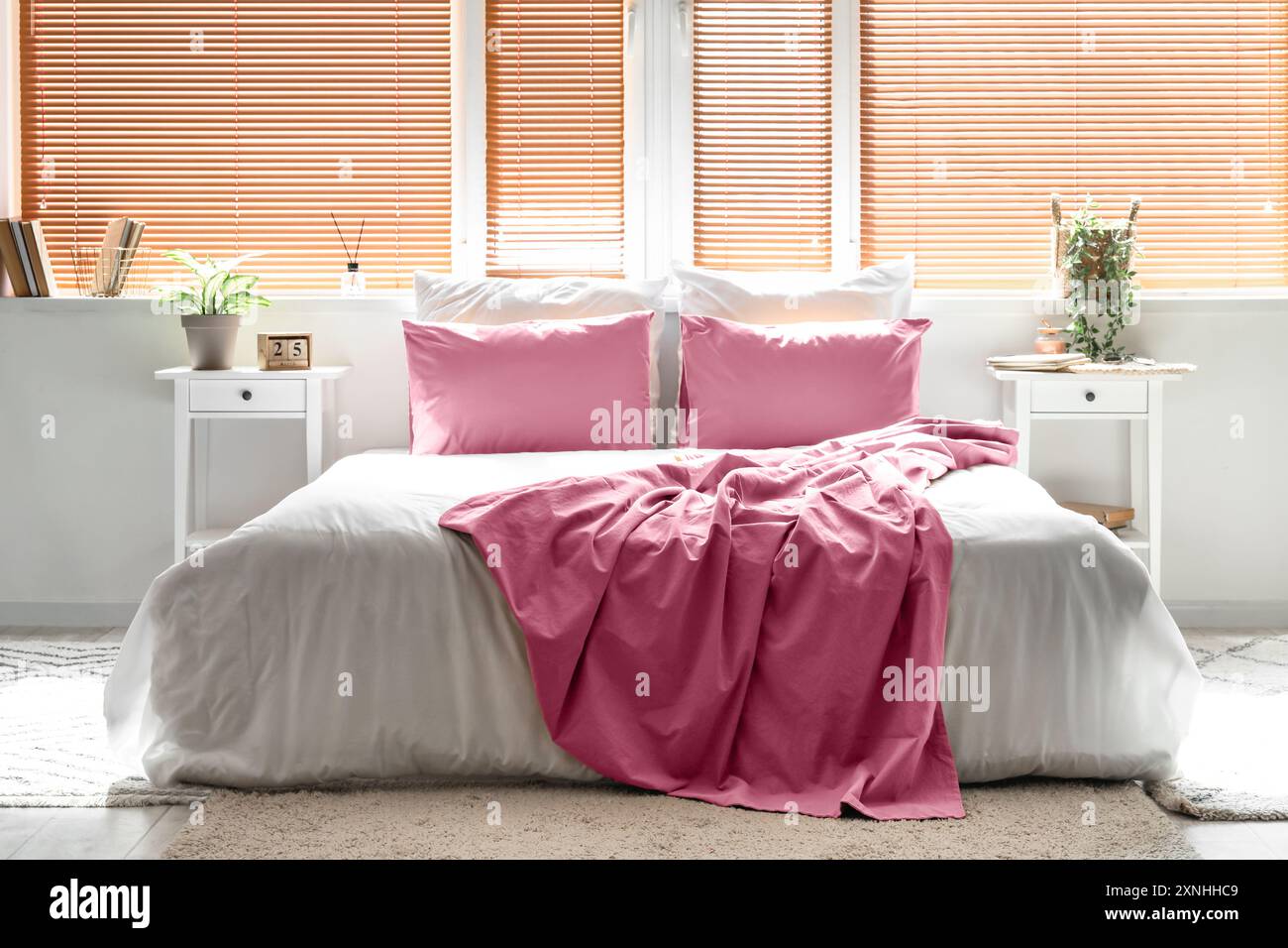 Interior of light bedroom with big bed, bedside tables and windows ...