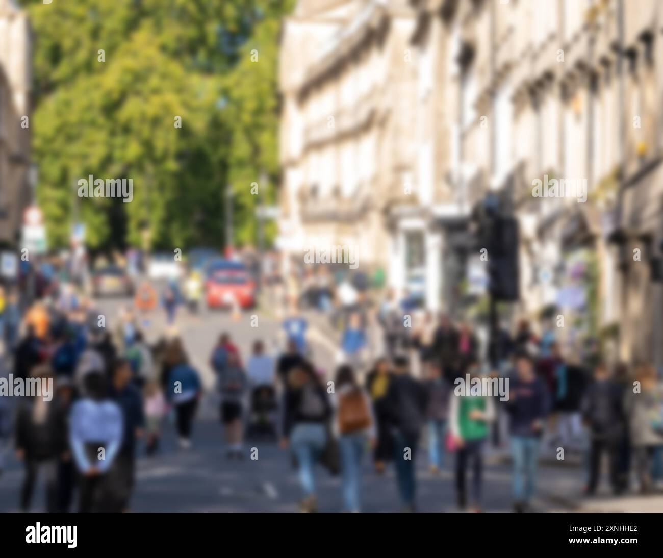 A blurry view of a crowded street in a city, with buildings on both ...