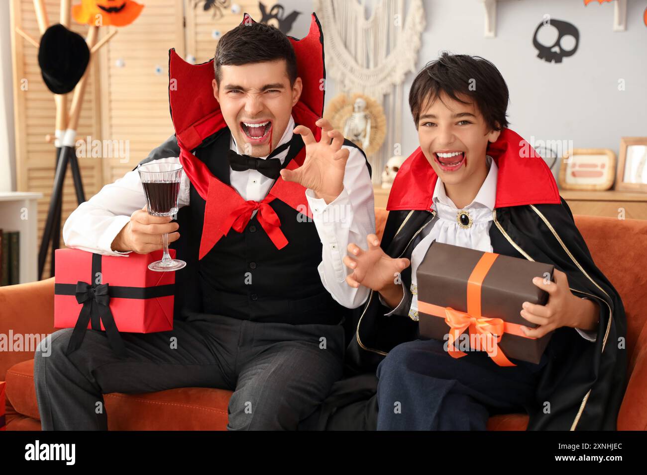 Little boy and his father dressed for Halloween as vampires with gifts ...