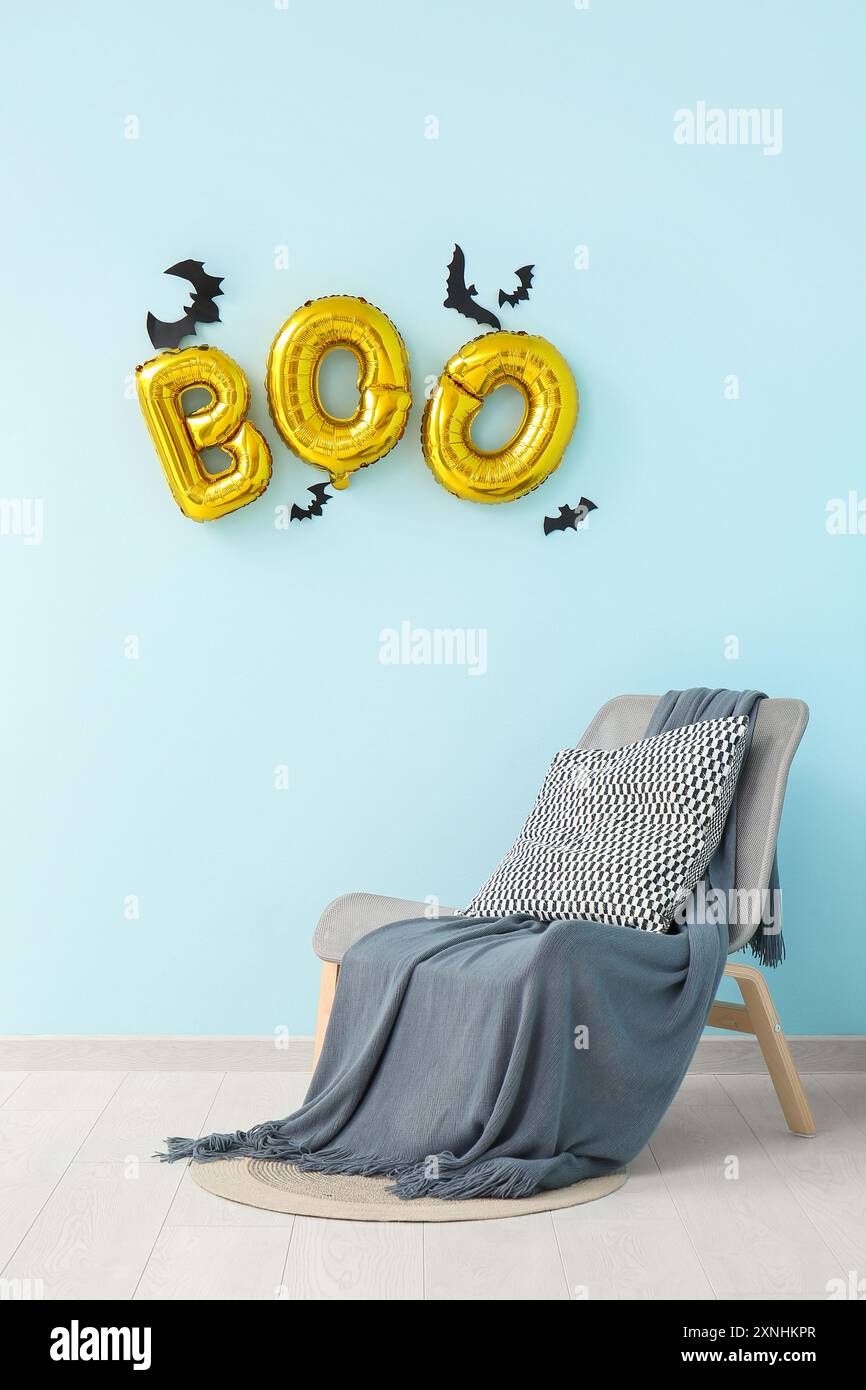 Word BOO made of balloons with paper bats and armchair in living room ...