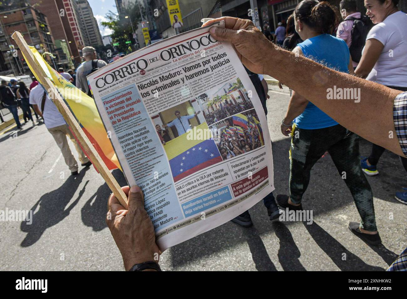 A man holds an official newspaper of the Venezuelan government with ...